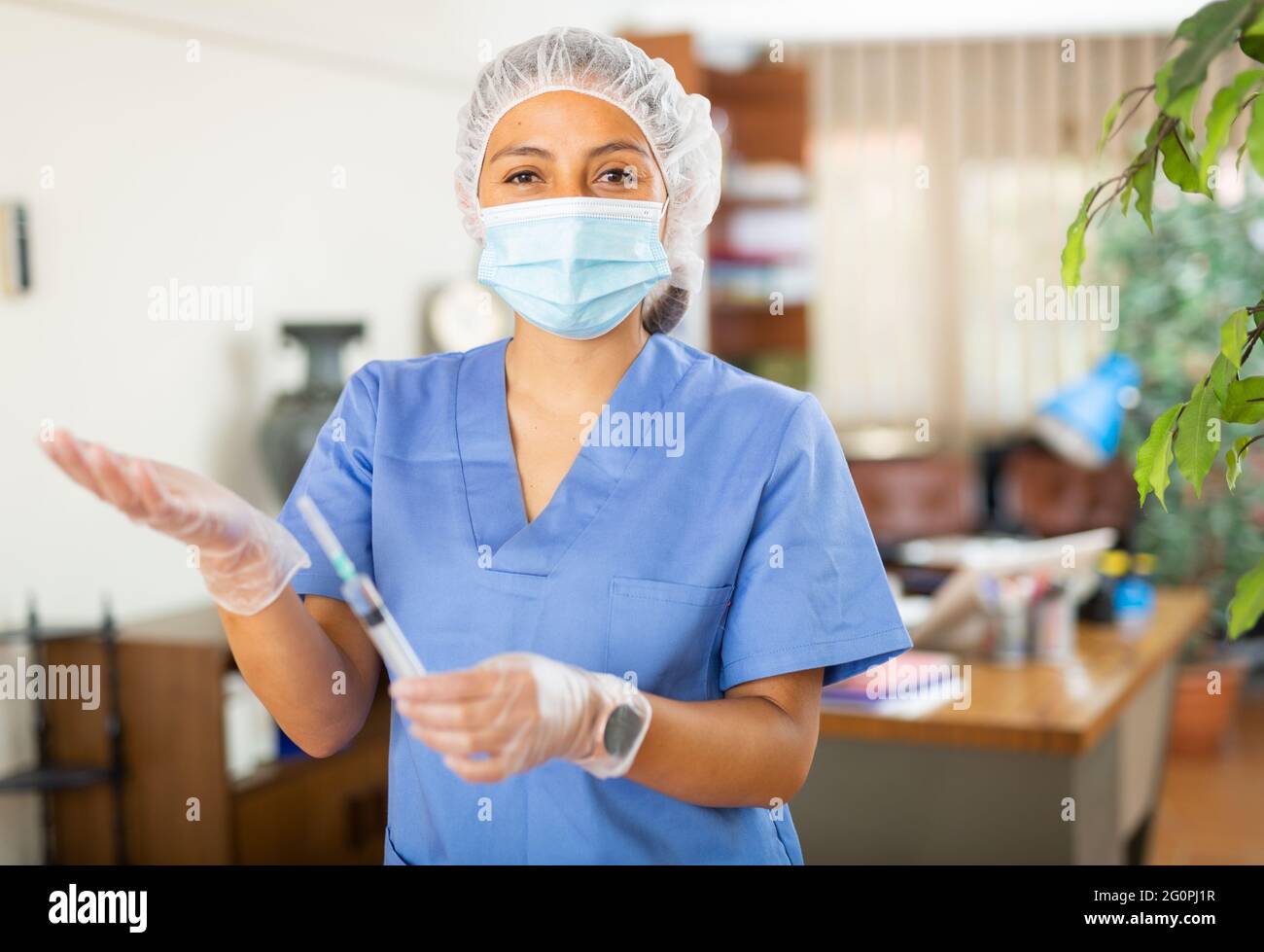 Positive woman healthcare worker holding syringe for injection Stock ...