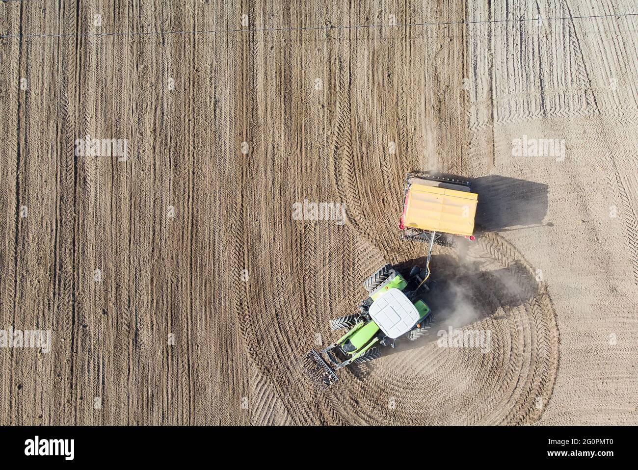 The farmer is creating interesting patterns on the dry fields while ...