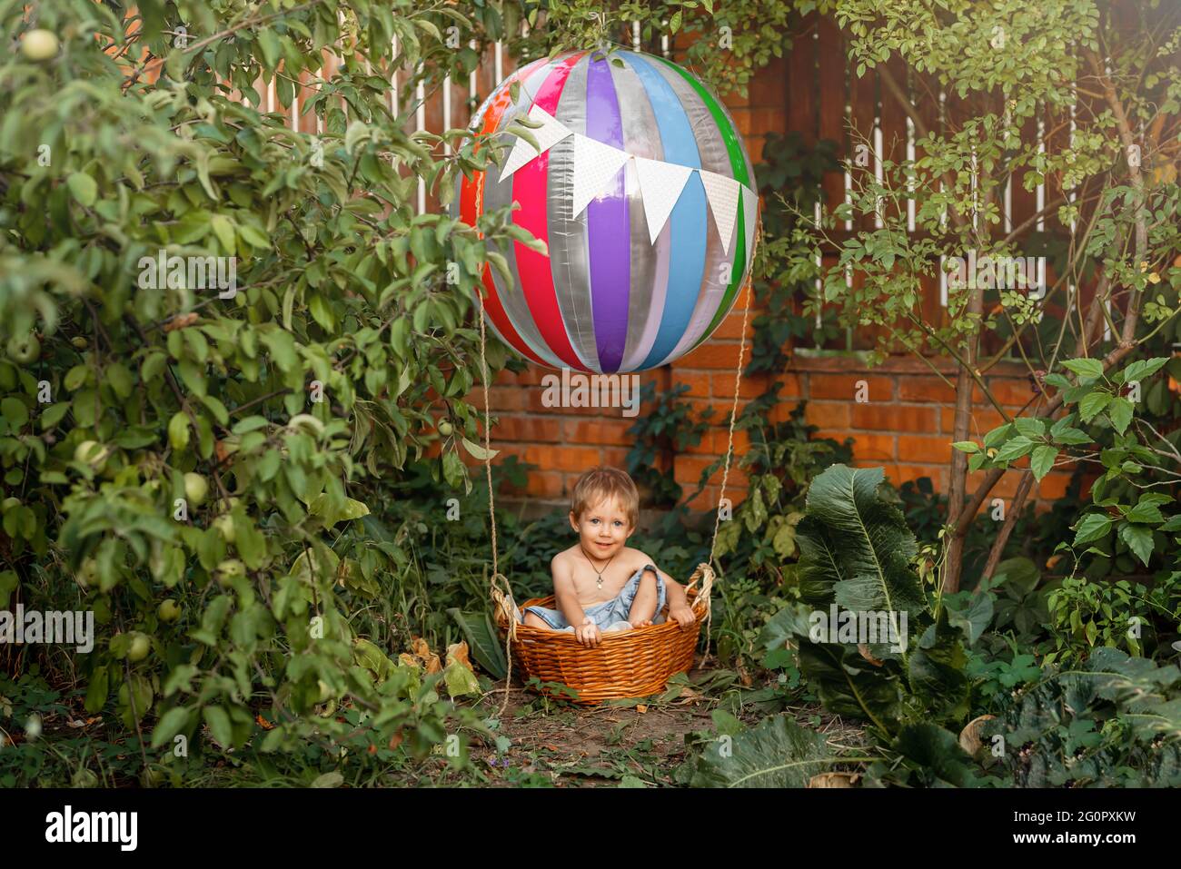 Happy kid boy having fun flying up on airship. Preschool boy traveling ...