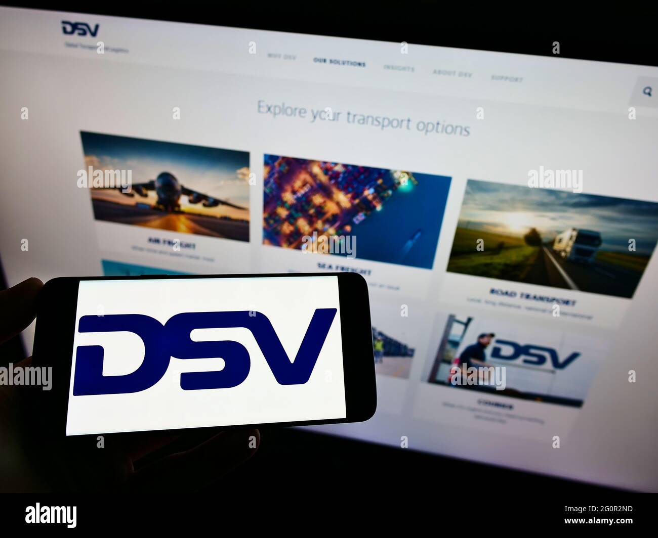 Person holding cellphone with business logo of Danish logistics company ...