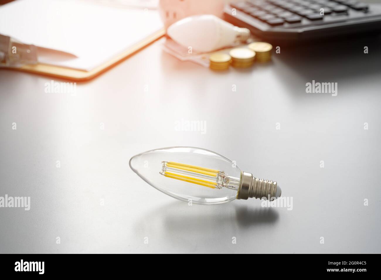 Light bulb and calculator on gray table Stock Photo - Alamy