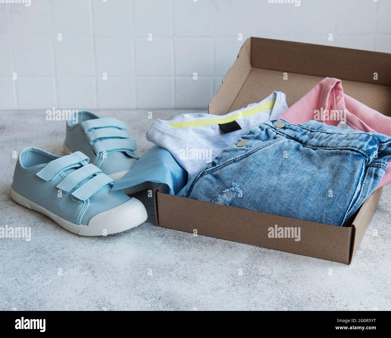 Clothes for kids in an open cardboard box. Online shopping concept ...