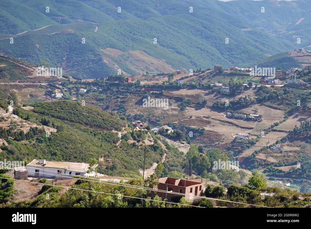 Aerial shot of cultivated lands and rural buildings in the mountains ...