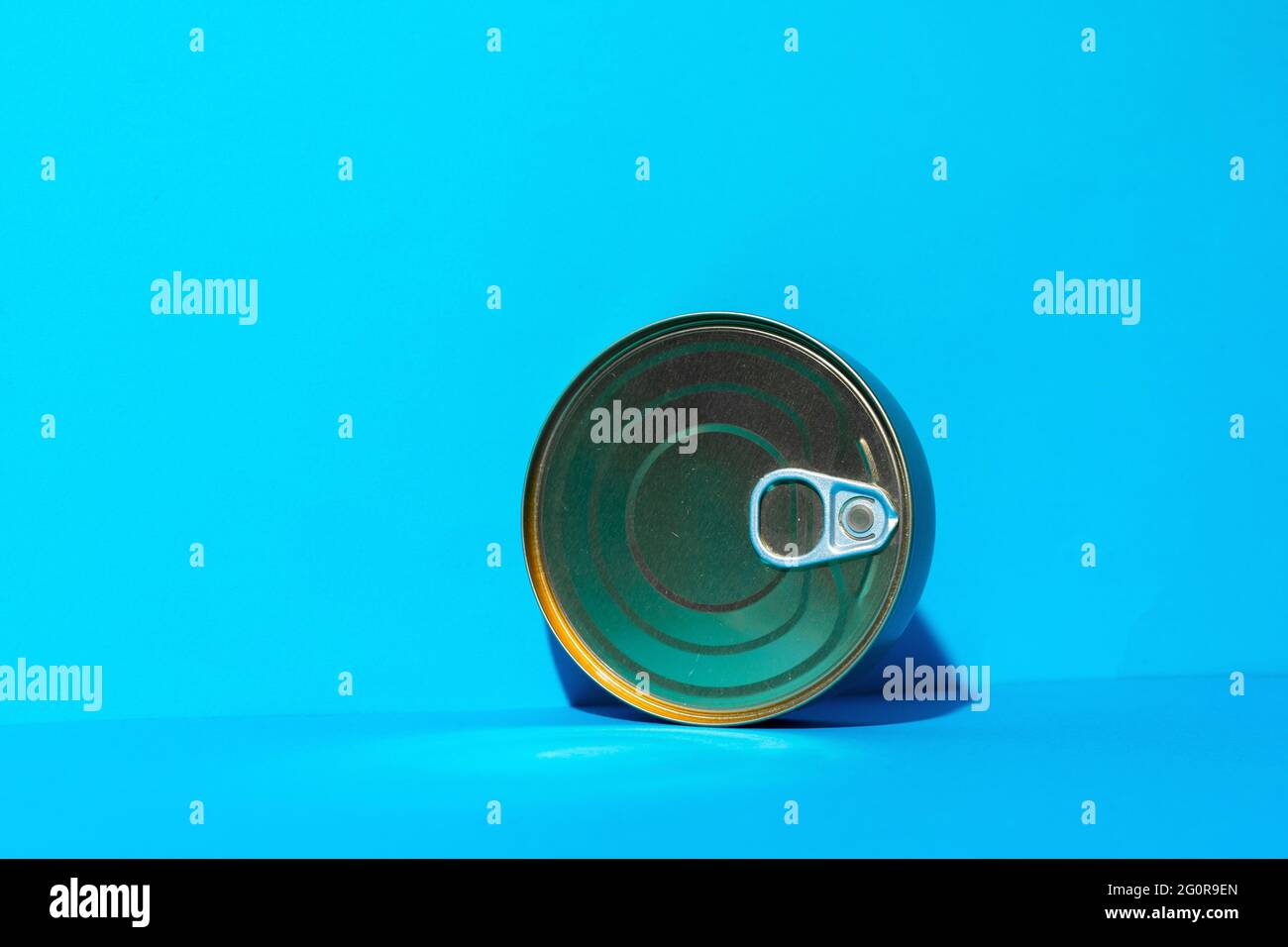 Tin can with food on blue background Stock Photo - Alamy