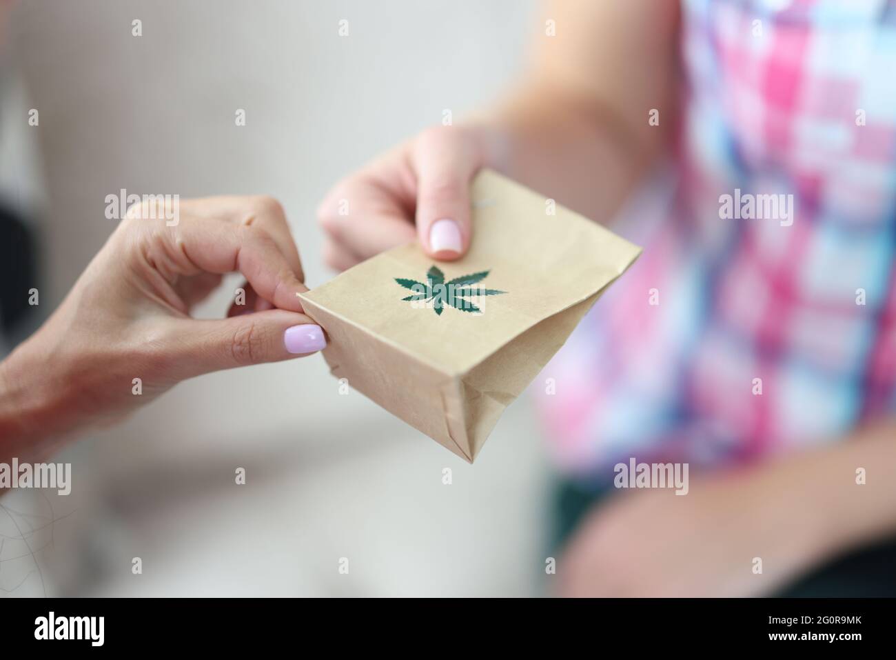Woman giving paper bag of marijuana closeup Stock Photo - Alamy
