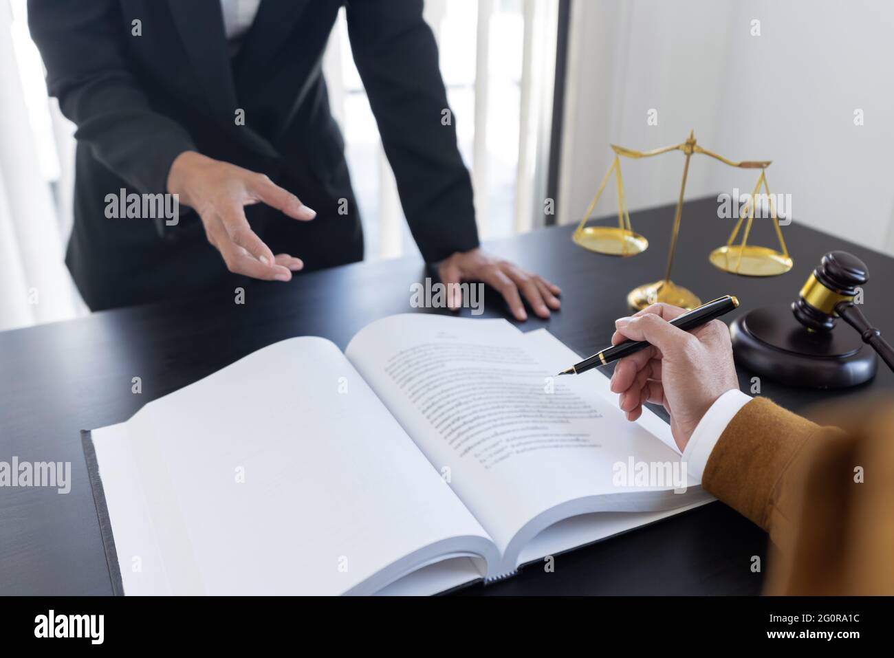 law,libra scale and hammer on the table, 2 lawyers are discussing about ...