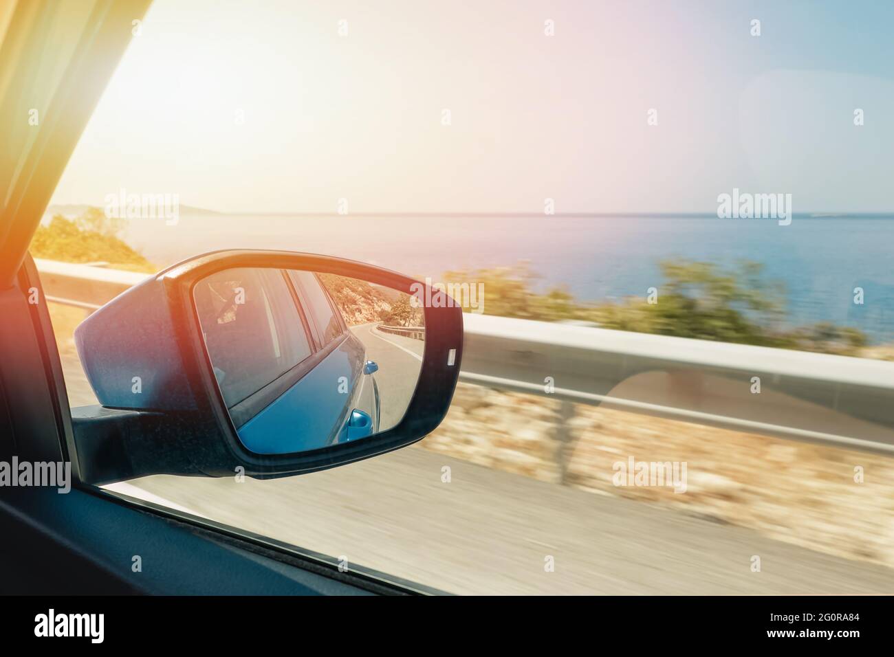 Close-up of side mirror of the moving car with reflection of the sea ...