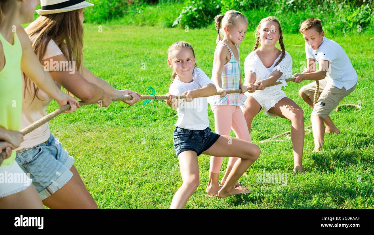 people with kids having fun outdoors pulling rope Stock Photo - Alamy