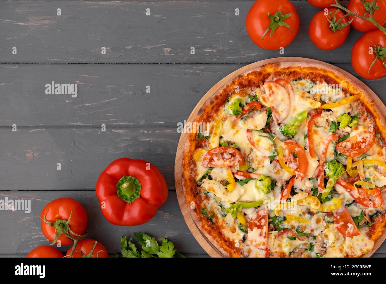 Delicious pizza on gray wooden background top view Stock Photo - Alamy
