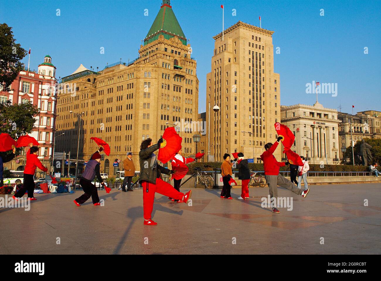 China. Shanghai. Chinese women dance with red fans on the bund in ...