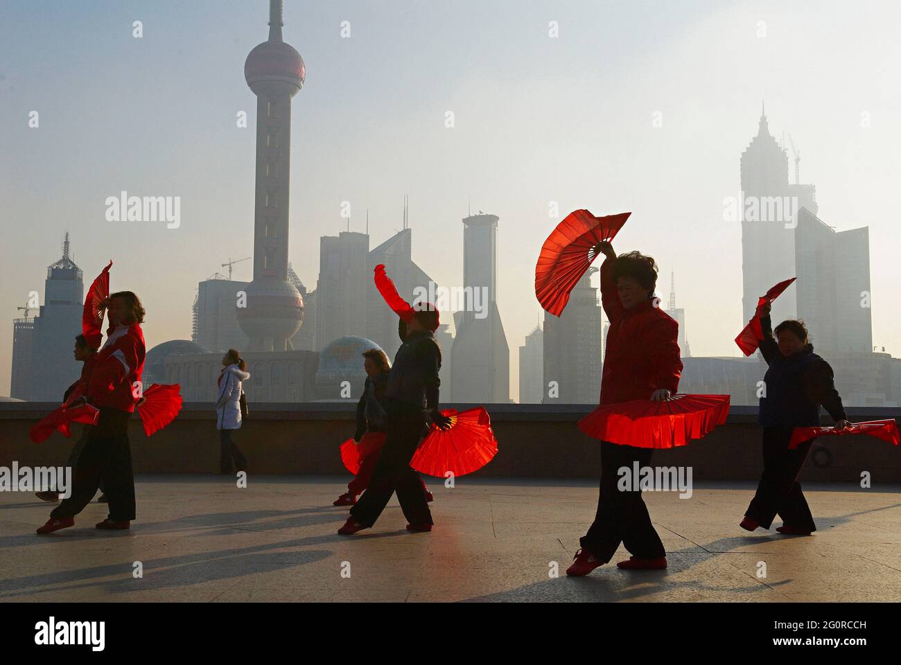China. Shanghai. Chinese women dance with red fans on the bund in ...