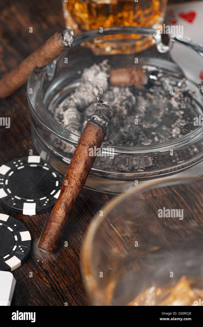 Playing poker with whiskey and cigars on table Stock Photo - Alamy