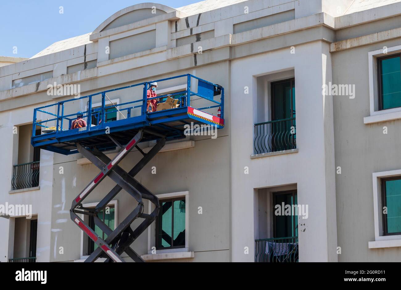 Shot of a maintenance workers working at heights, repairing facade of ...