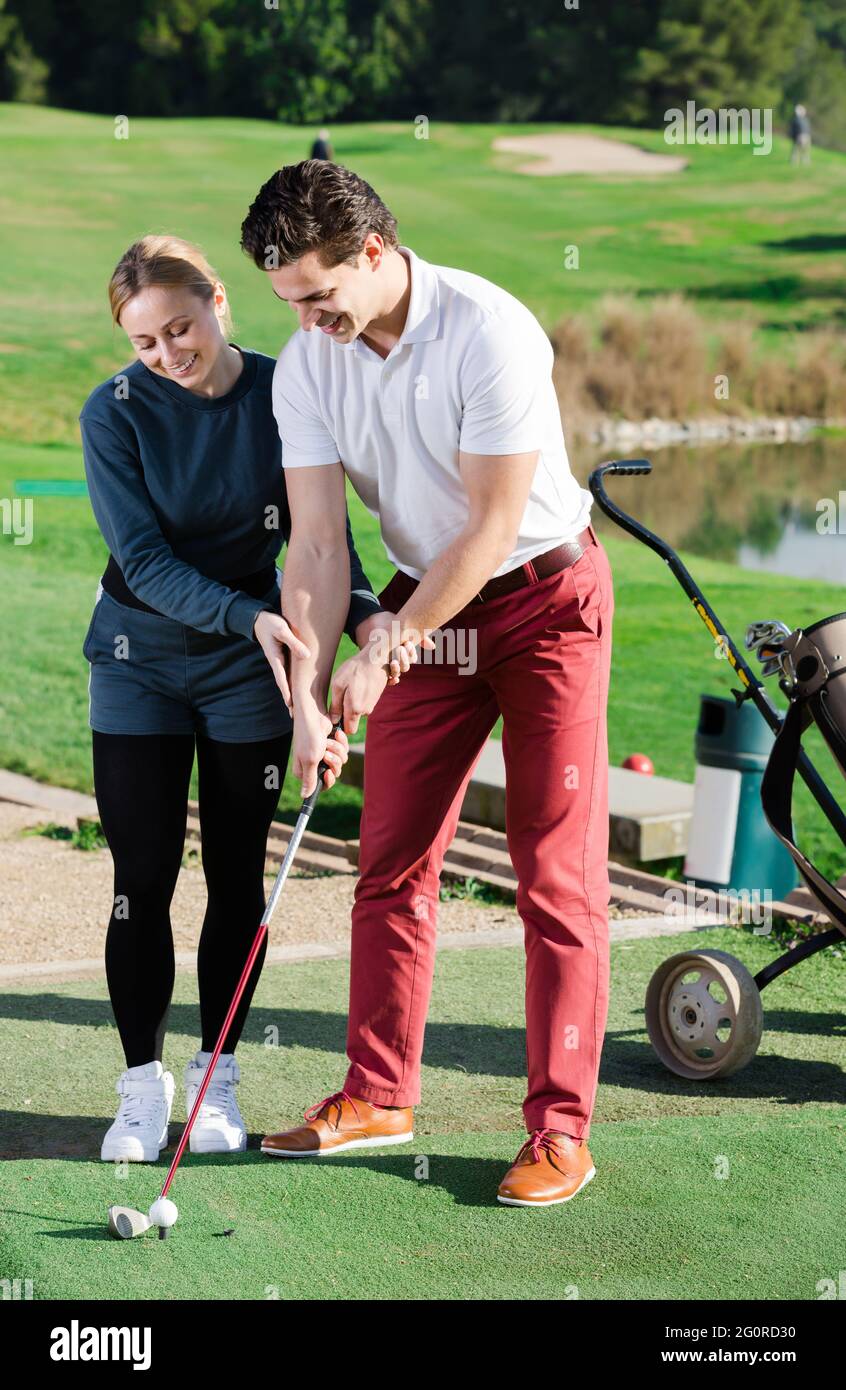 Young trainer showing player how to hit ball Stock Photo - Alamy