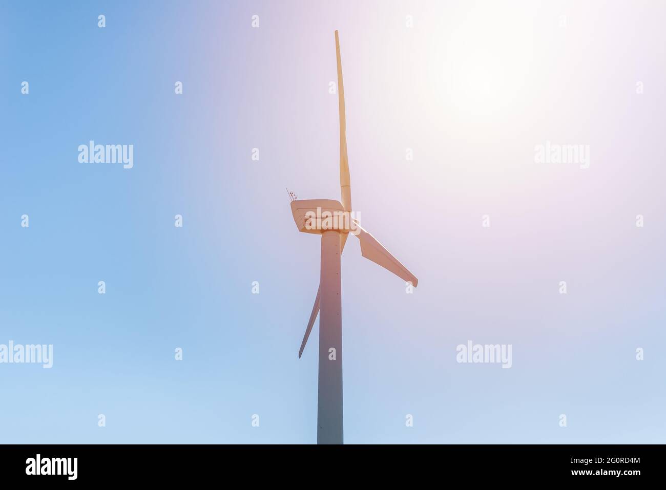 Wind power,one wind turbine blue skyand sun.wind power concept with ...