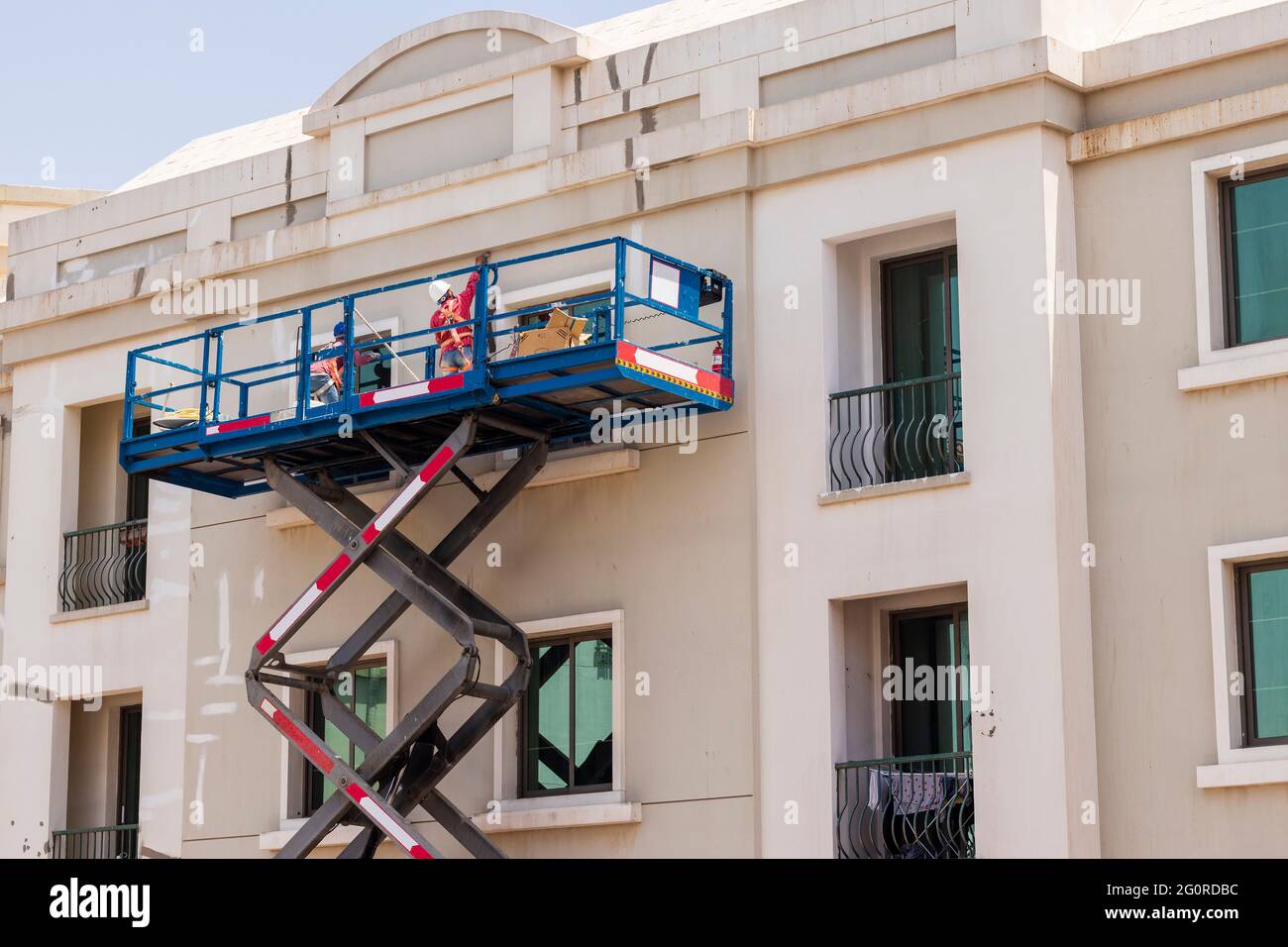 Shot of a maintenance workers working at heights, repairing facade of ...