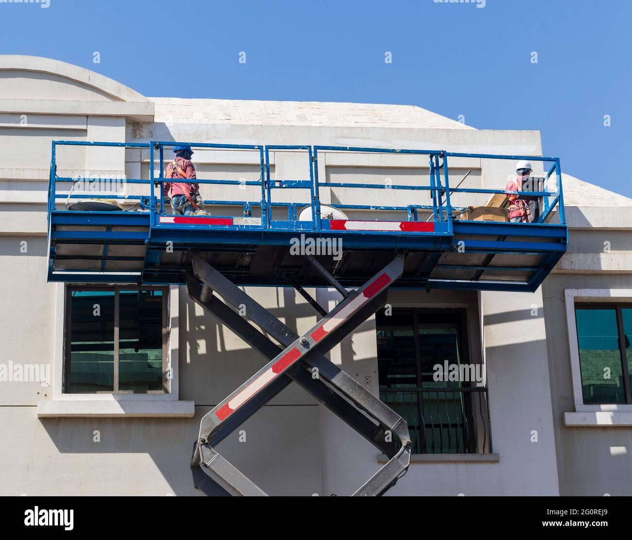 Shot of a maintenance workers working at heights, repairing facade of ...
