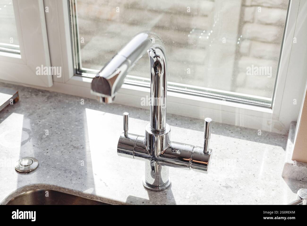 Silver faucet in the kitchen near window Stock Photo - Alamy