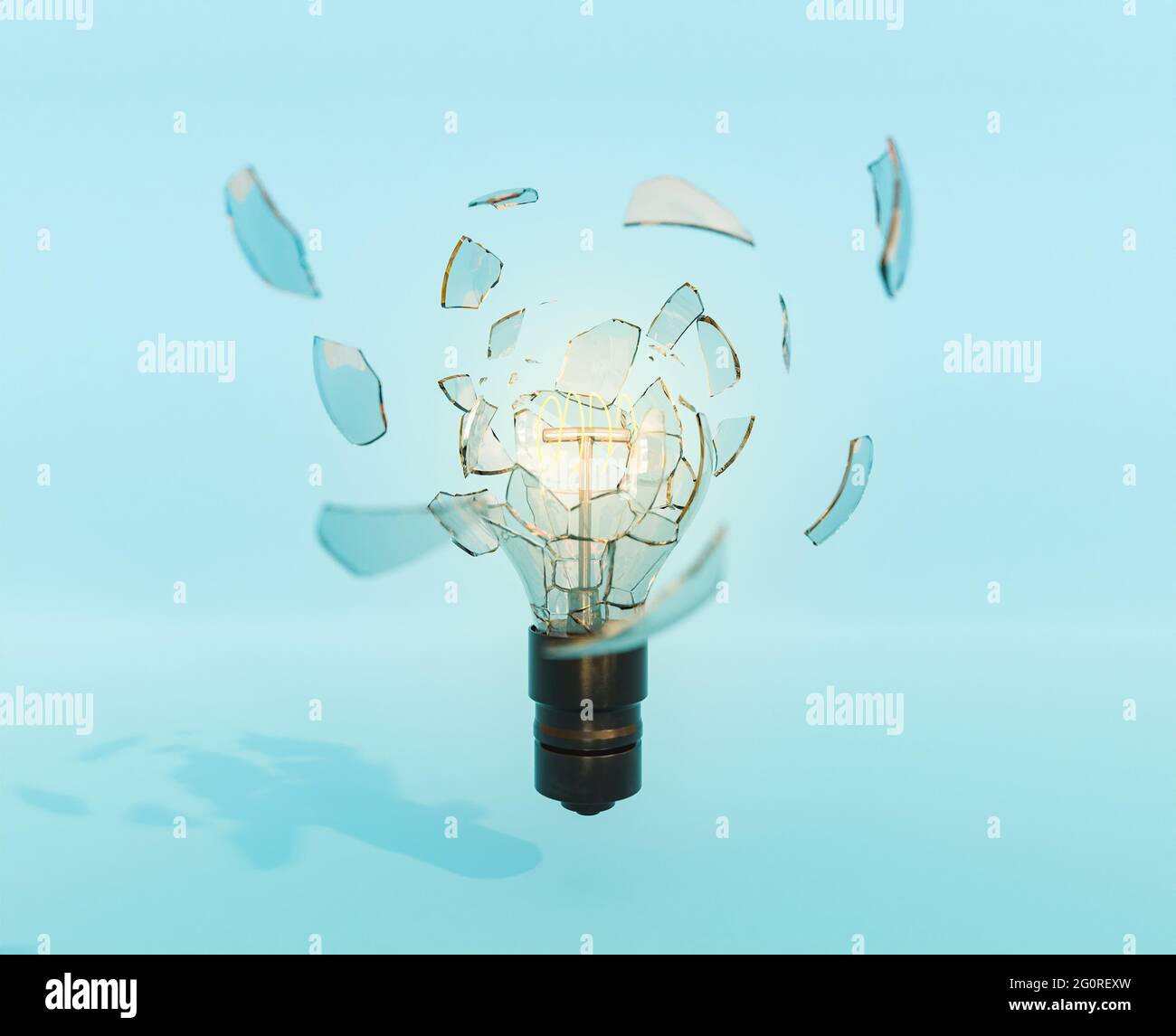 broken light bulb with pieces of glass around it and illuminated ...