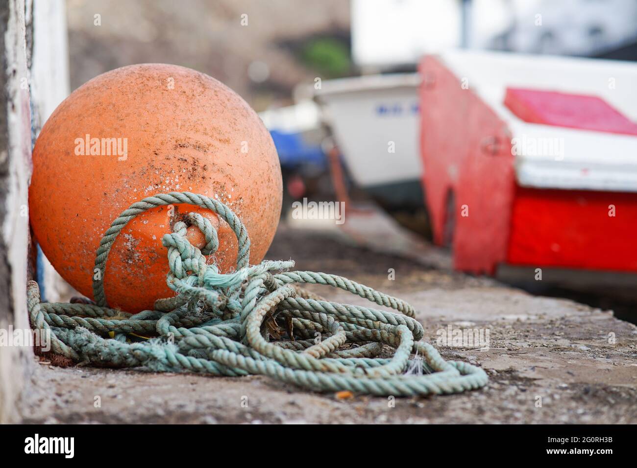 Old orange buoy at the harbor Stock Photo - Alamy