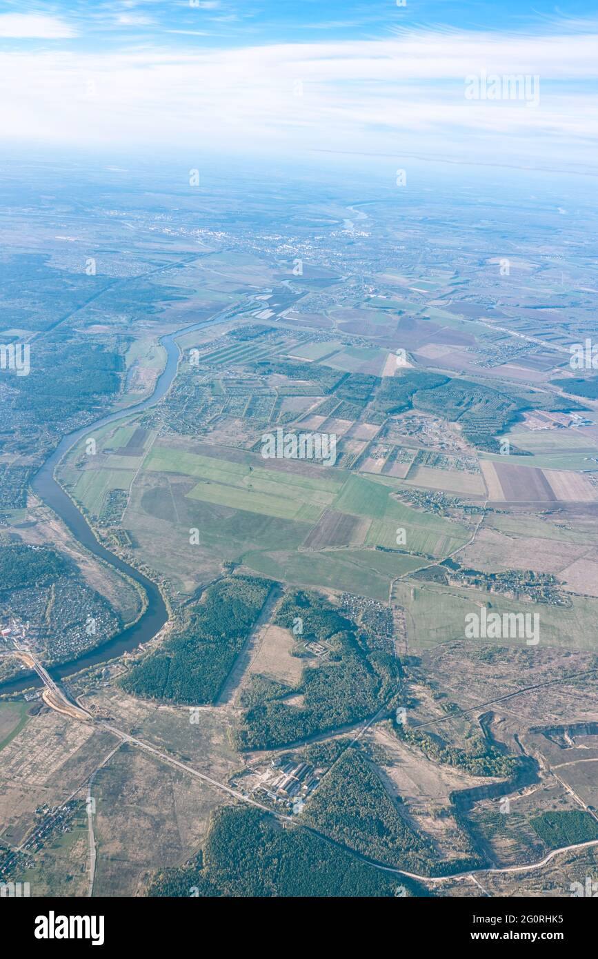 Aerial view from airplane window above green ground. View from the ...
