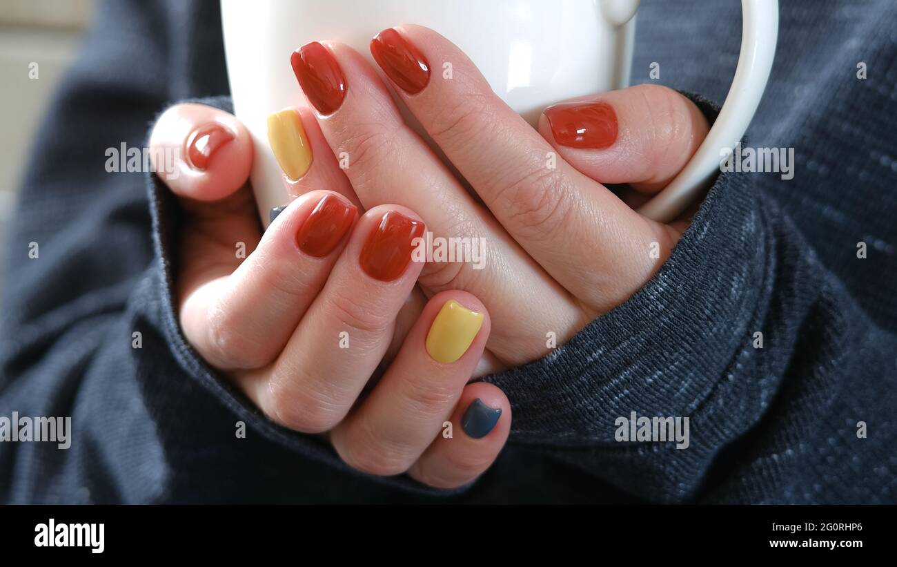 The girl warms up, holding a cup of coffee in her hands. Well-groomed ...