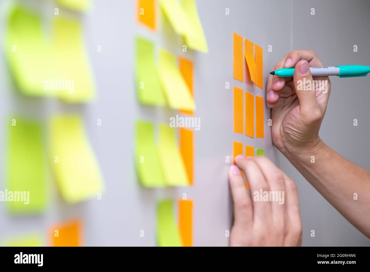 IT worker tracking his tasks on kanban board. Using task control of agile development ...