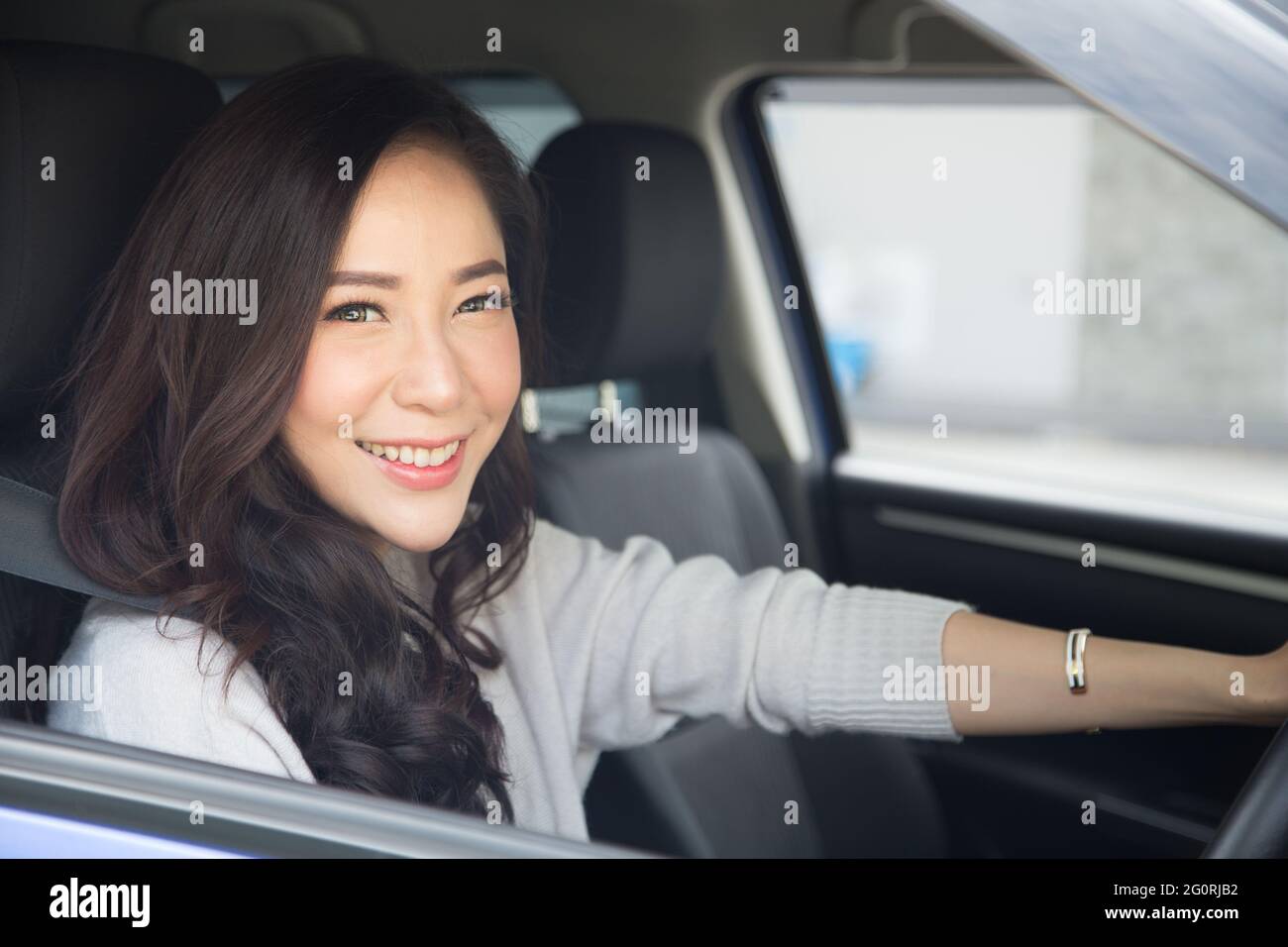 Asian women driving a car and smile happily with glad positive ...