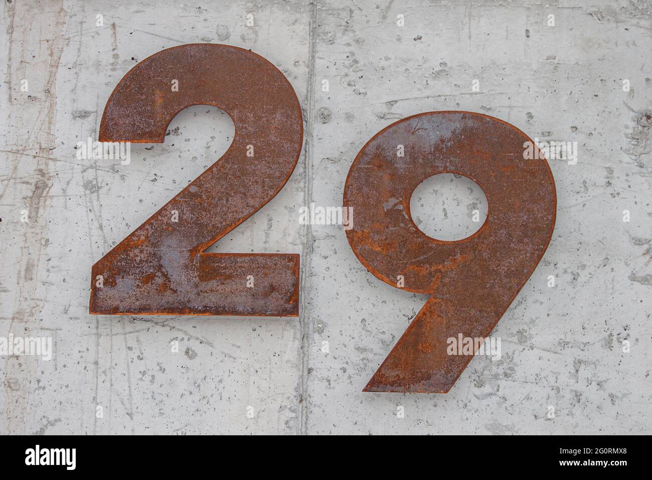 Rusty numbers of the number 29 on the background of a concrete wall ...