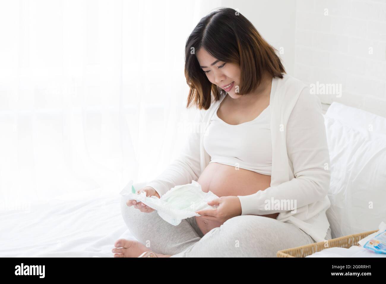 Pregnant women prepare diapers for newborn Stock Photo - Alamy