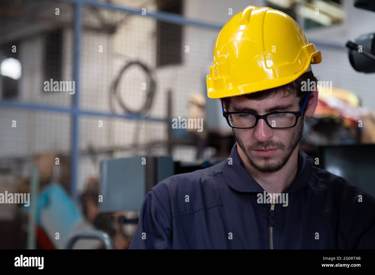 Portrait of industrial engineer wearing hard hat while standing in the ...