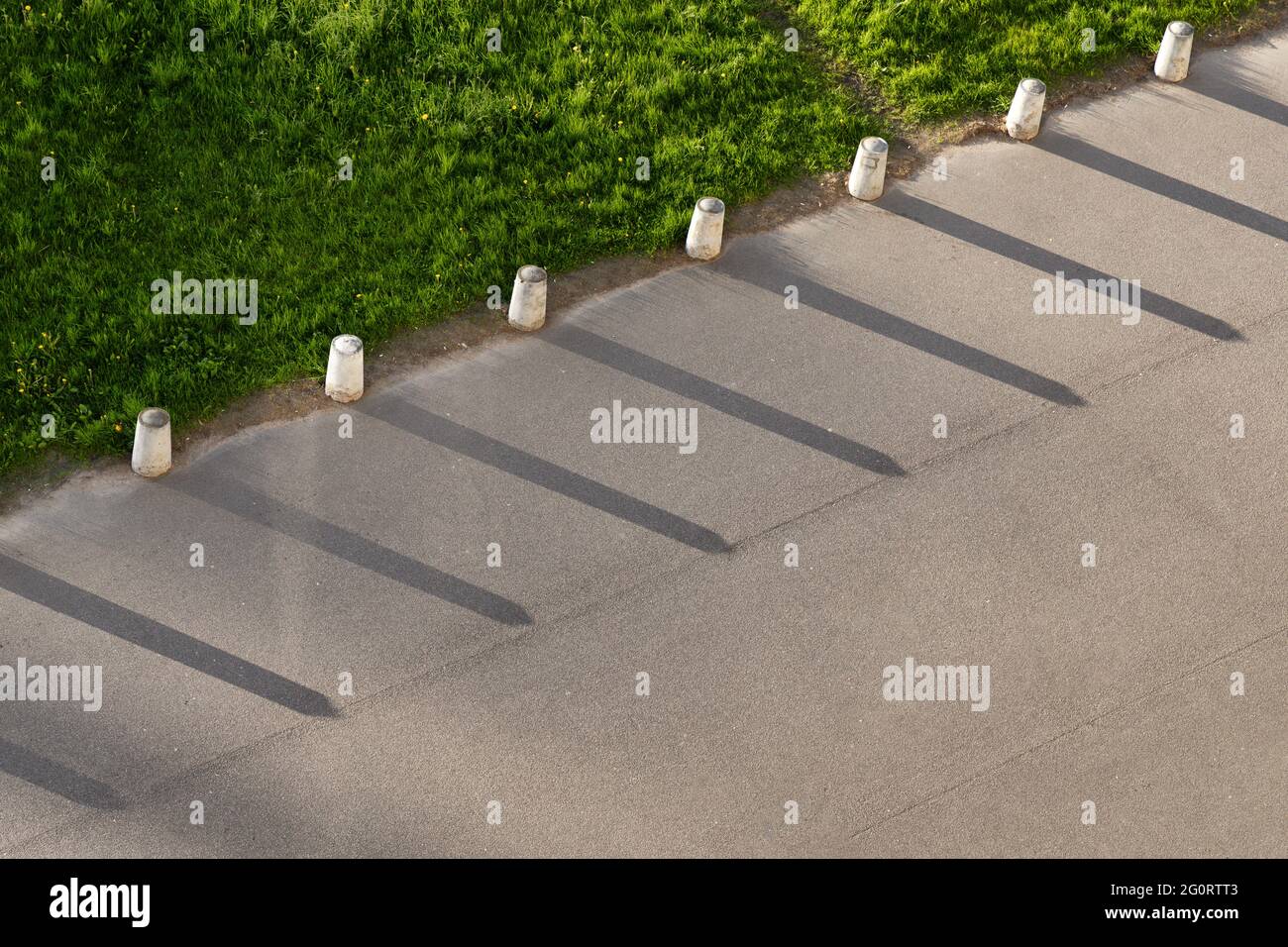 Small road columns with long shadows in the evening light on the edge ...