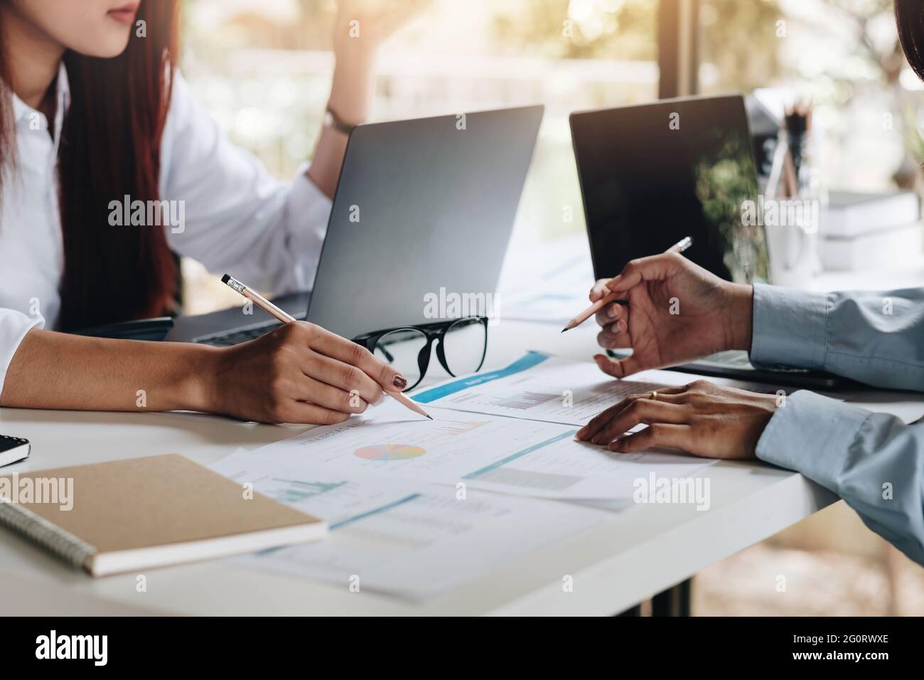 Business group or business partners discussing documents and ideas at ...