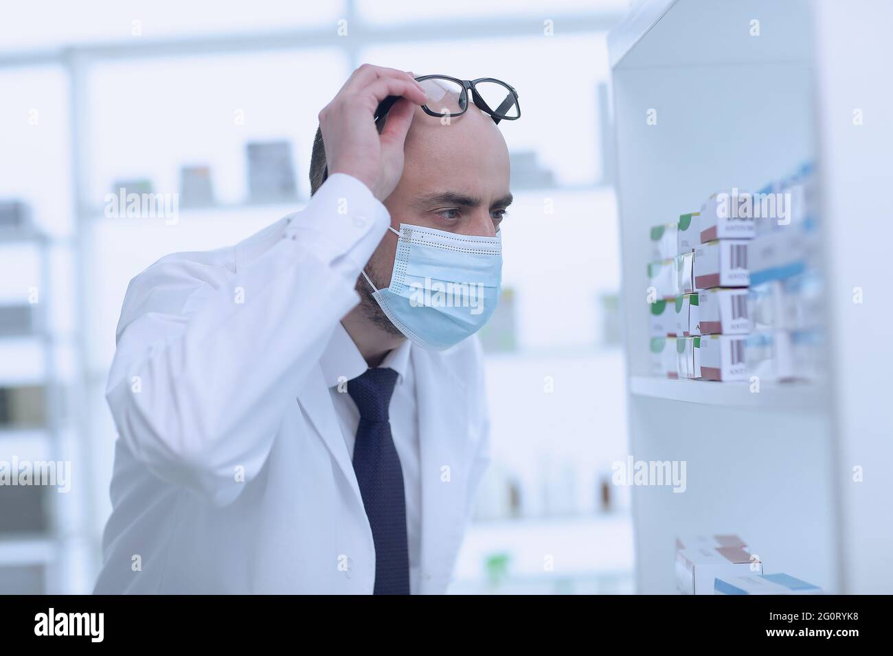 Man pharmacist in protective face mask working in pharmacy Stock Photo ...