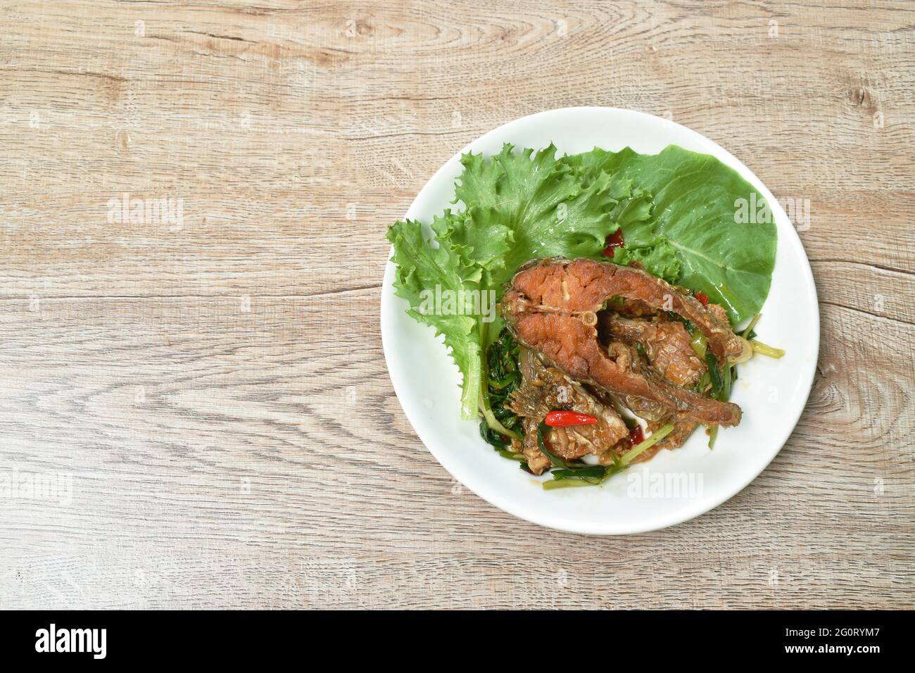 deep fried slice striped snake head fish with ginger and celery on dish ...