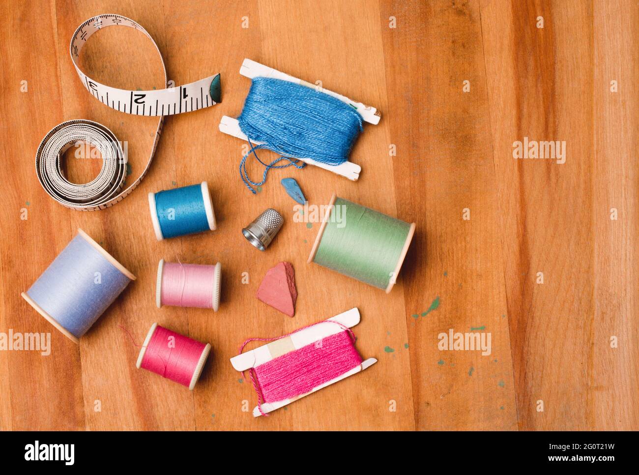 Sewing thread spools and accessories on wood table with copy space ...