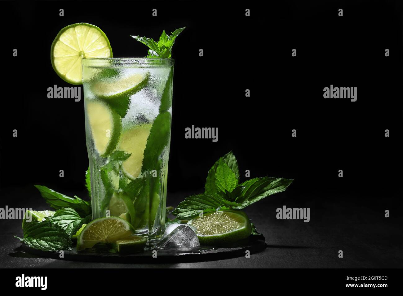 Fresh homemade mojito cocktail in a tall glass with lime, mint and ice ...