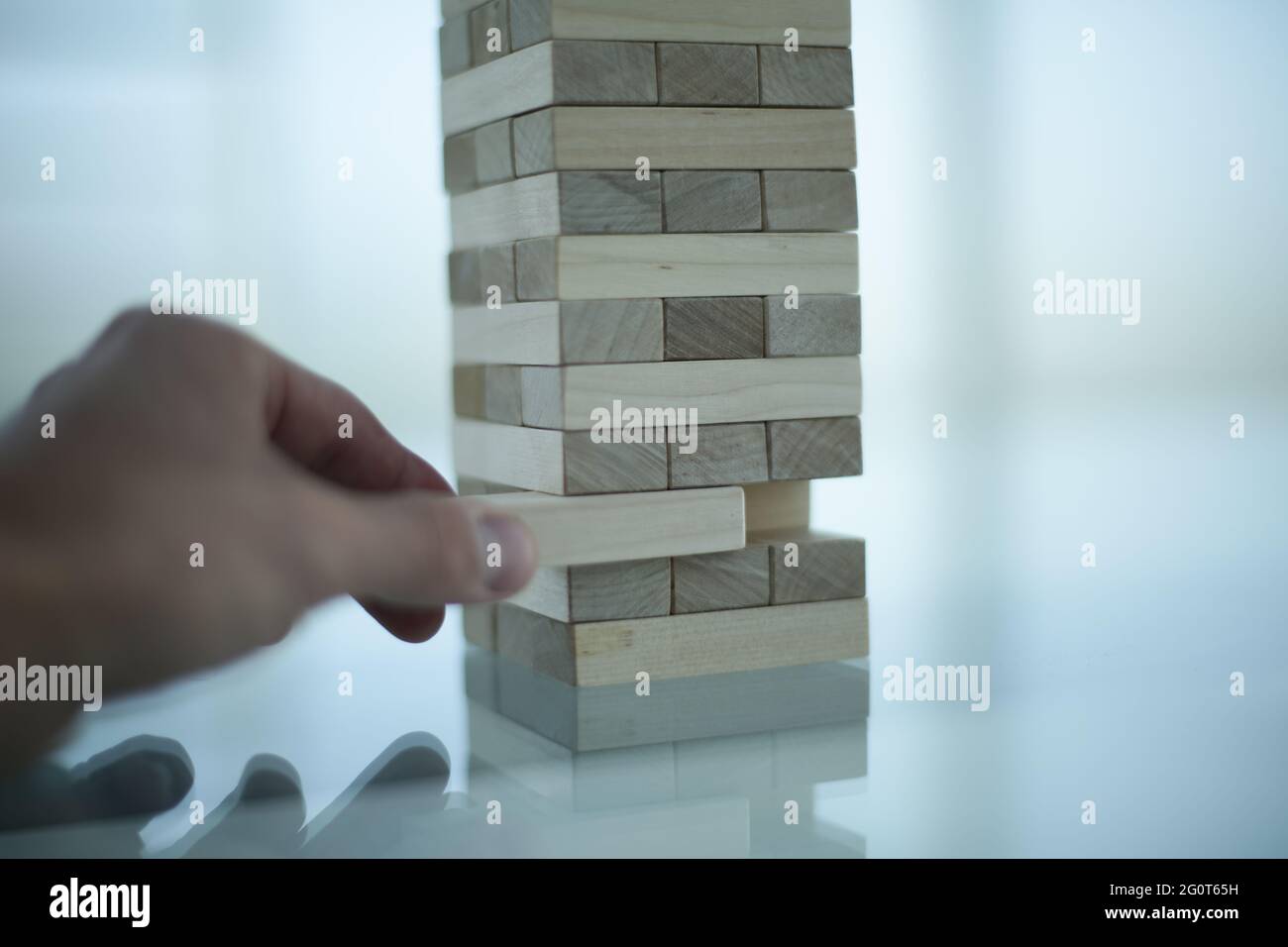 Man holds in hand one wooden piece of Jenga board game Stock Photo - Alamy
