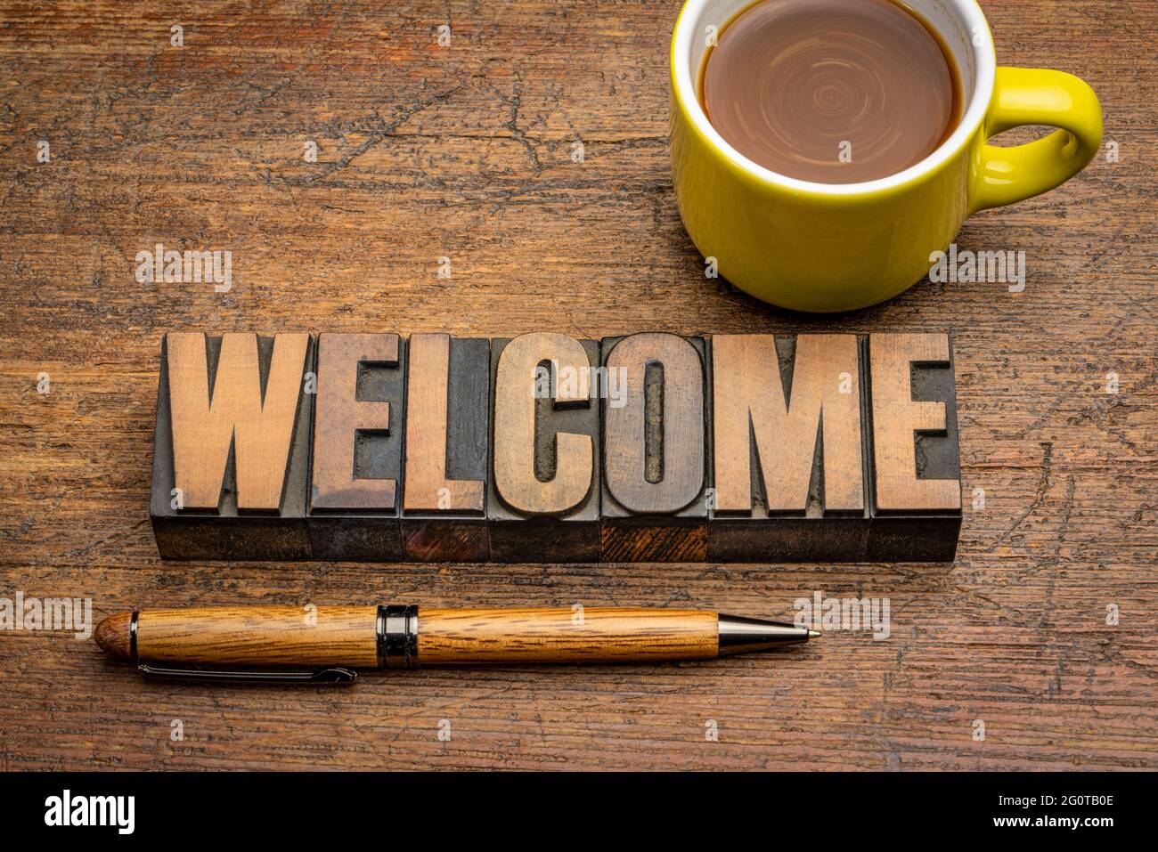 welcome sign - word in vintage letterpress wood type with a cup of ...
