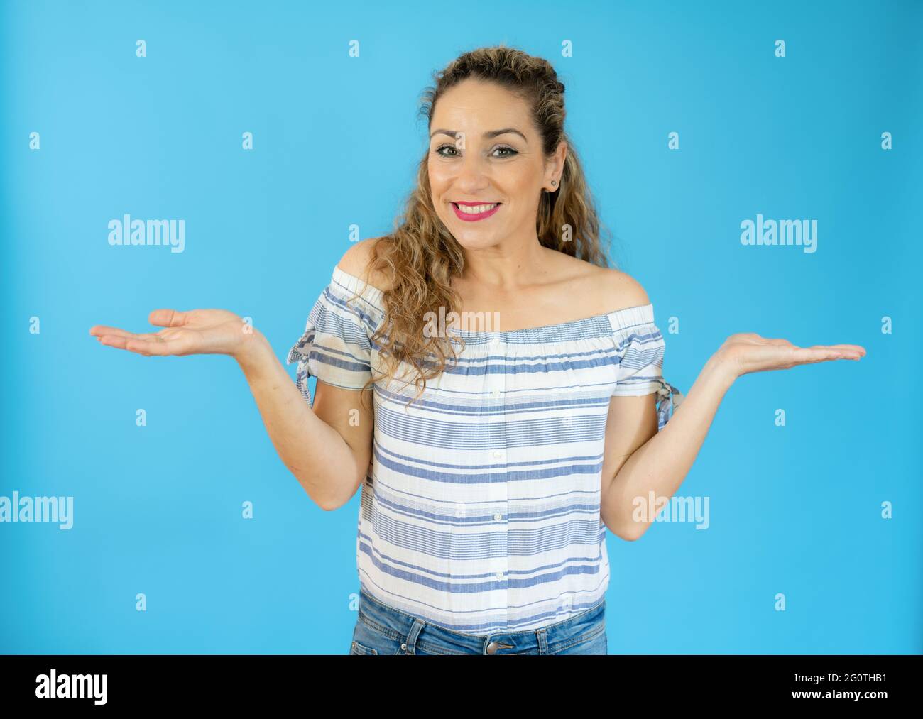Young woman clueless and confused with open arms, no idea and doubtful ...