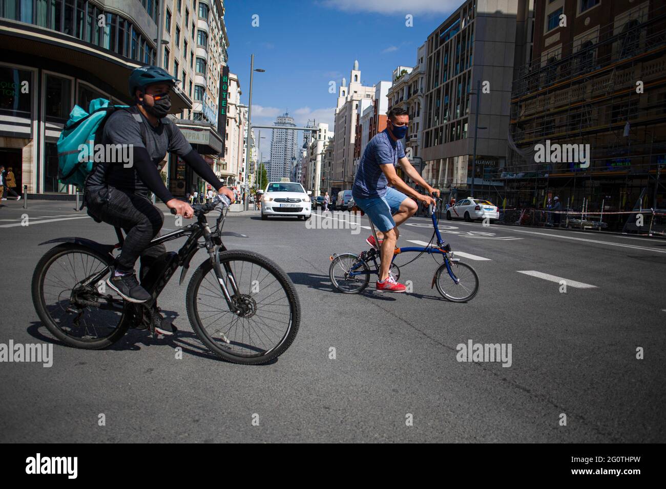 Madrid, Spain. 03rd June, 2021. Two men on bicycles ride through a ...