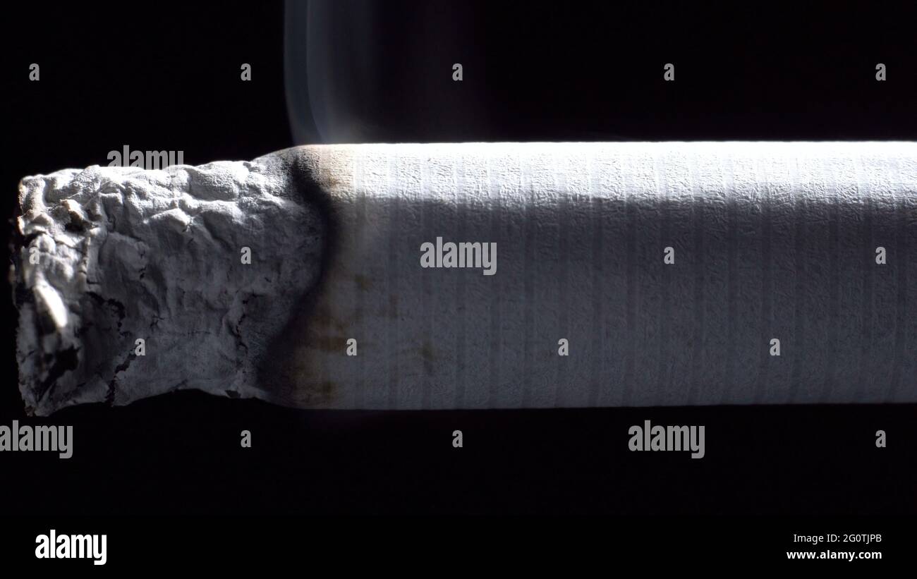 Shooting of smoldering cigarette in shadow on black Stock Photo - Alamy