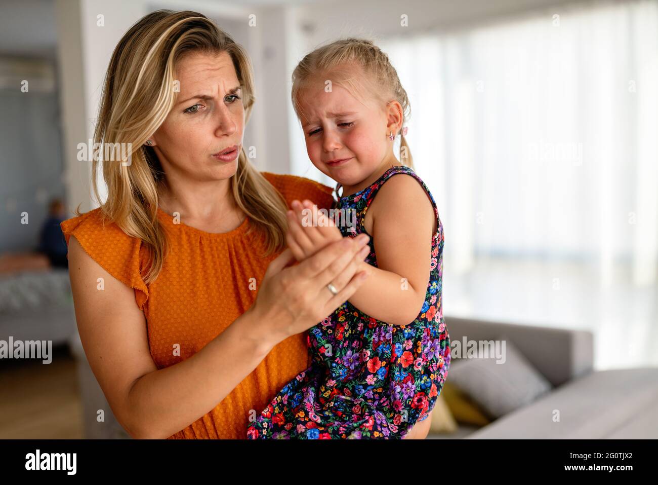 Mother comforting her crying child after she hit her hand Stock Photo ...