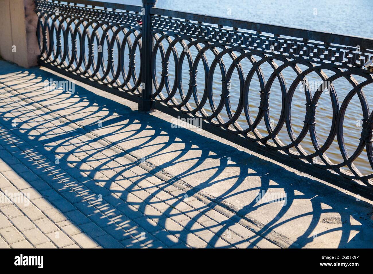 Shadows on a sunny day from the metal railings on the bridge over the ...
