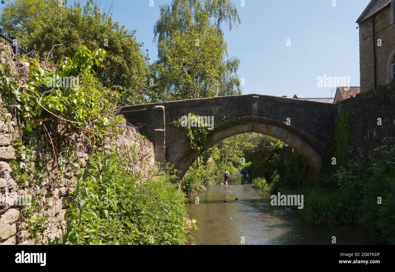 two teenage boys walking down the River Brue in Bruton Somerset, in ...