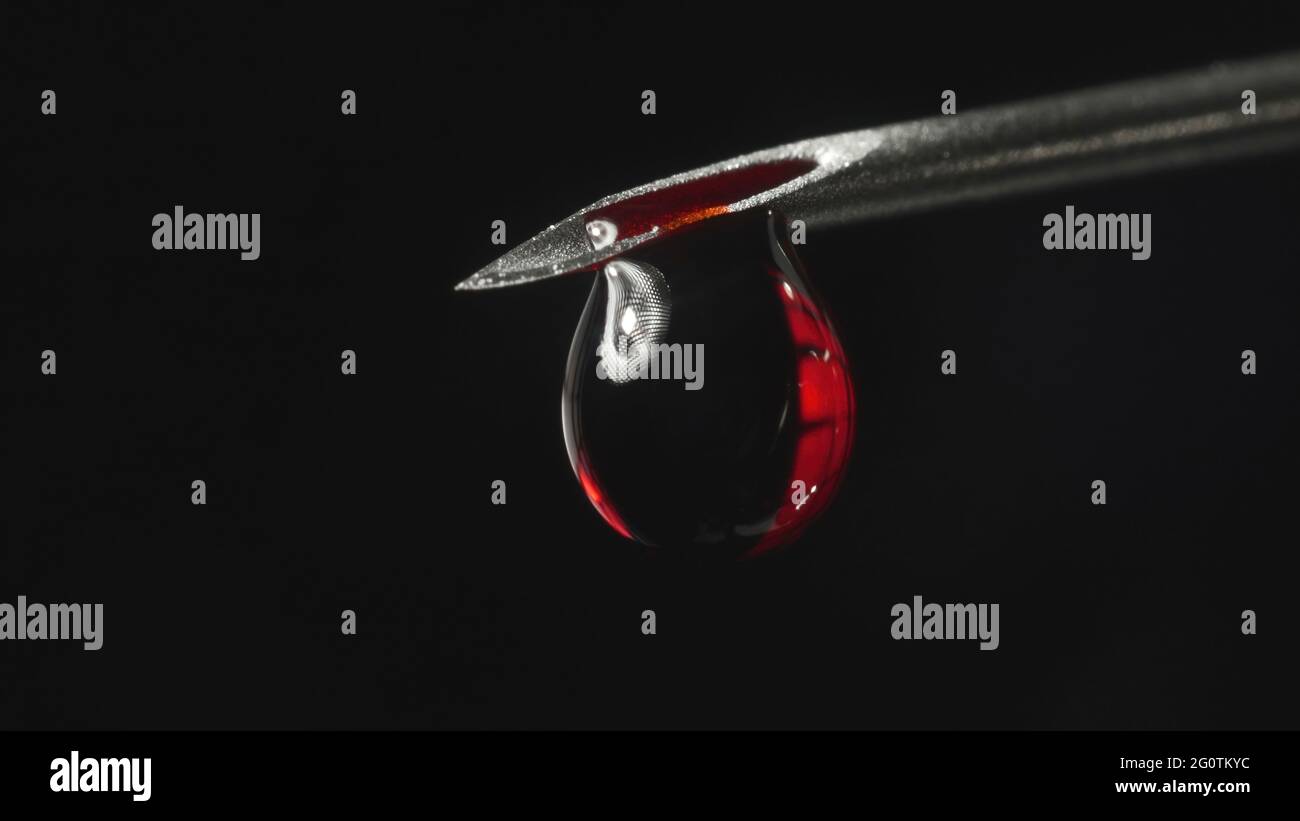Shooting of syringe needle with drop of red liquid Stock Photo - Alamy