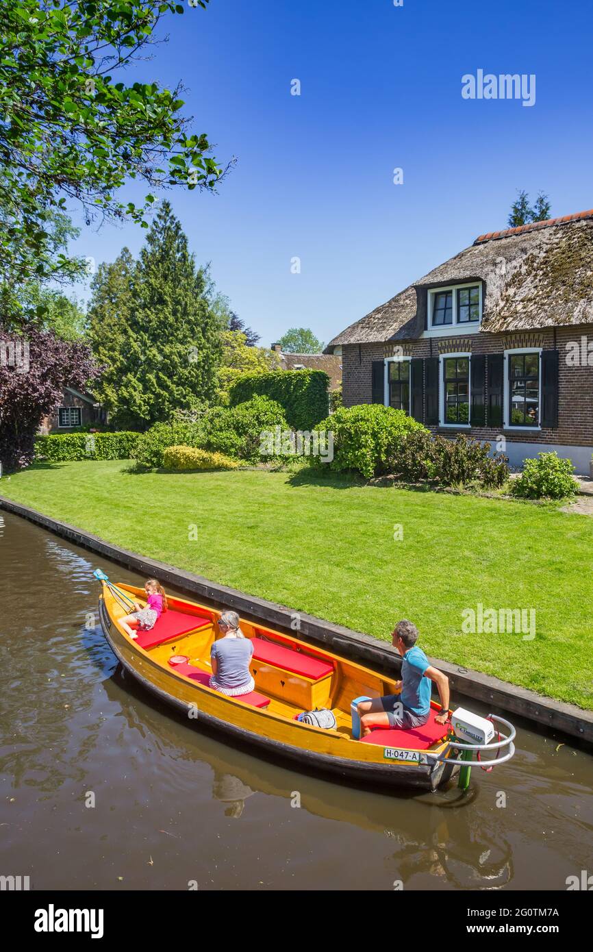 Colorful electric motorboat in the historic canal of Giethoorn ...