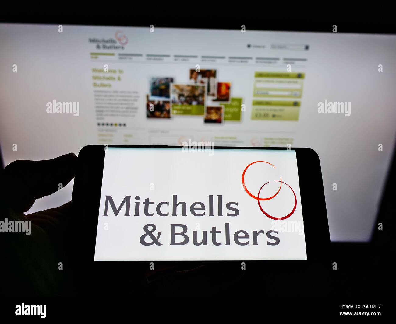 Person holding smartphone with logo of British restaurant company ...