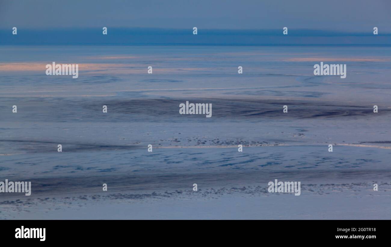 An elevated pipeline running above ground and the frozen tundra from ...