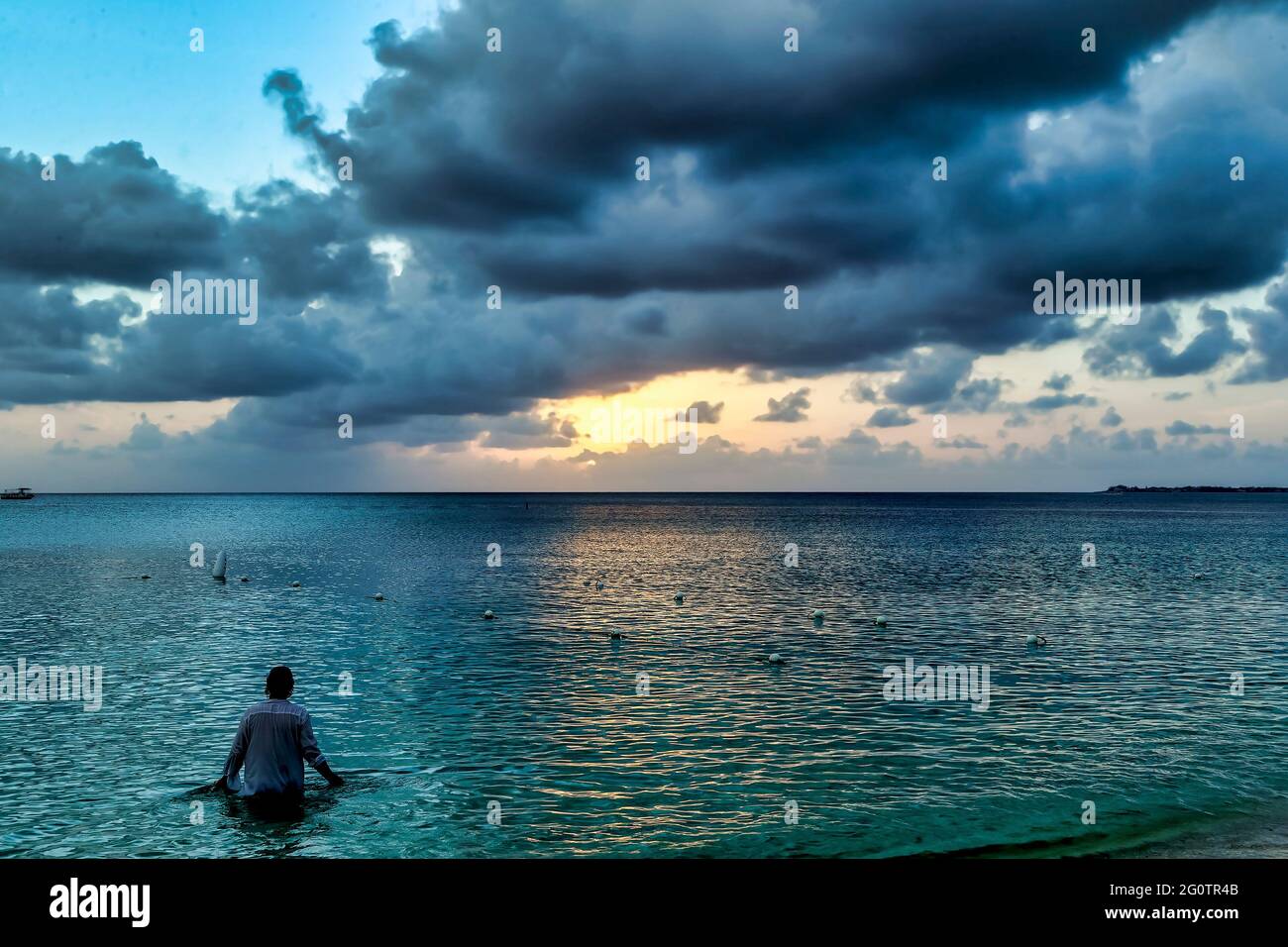 Swimmers in the water at sunset in the Caribbean Stock Photo - Alamy